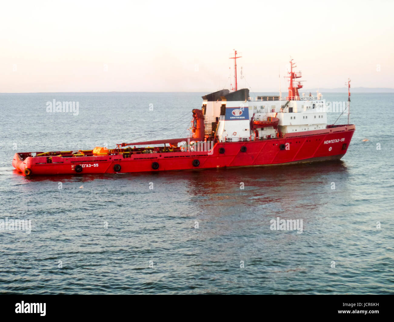 A small service ship in a cargo industrial port. A ship in the sea ...