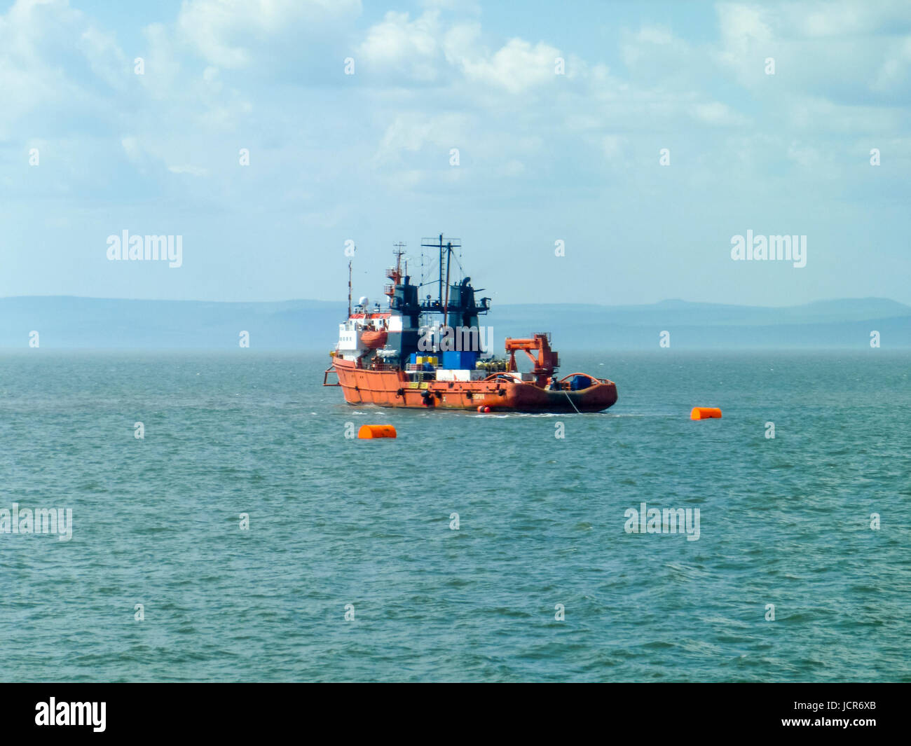 A small service ship in a cargo industrial port. A ship in the sea ...