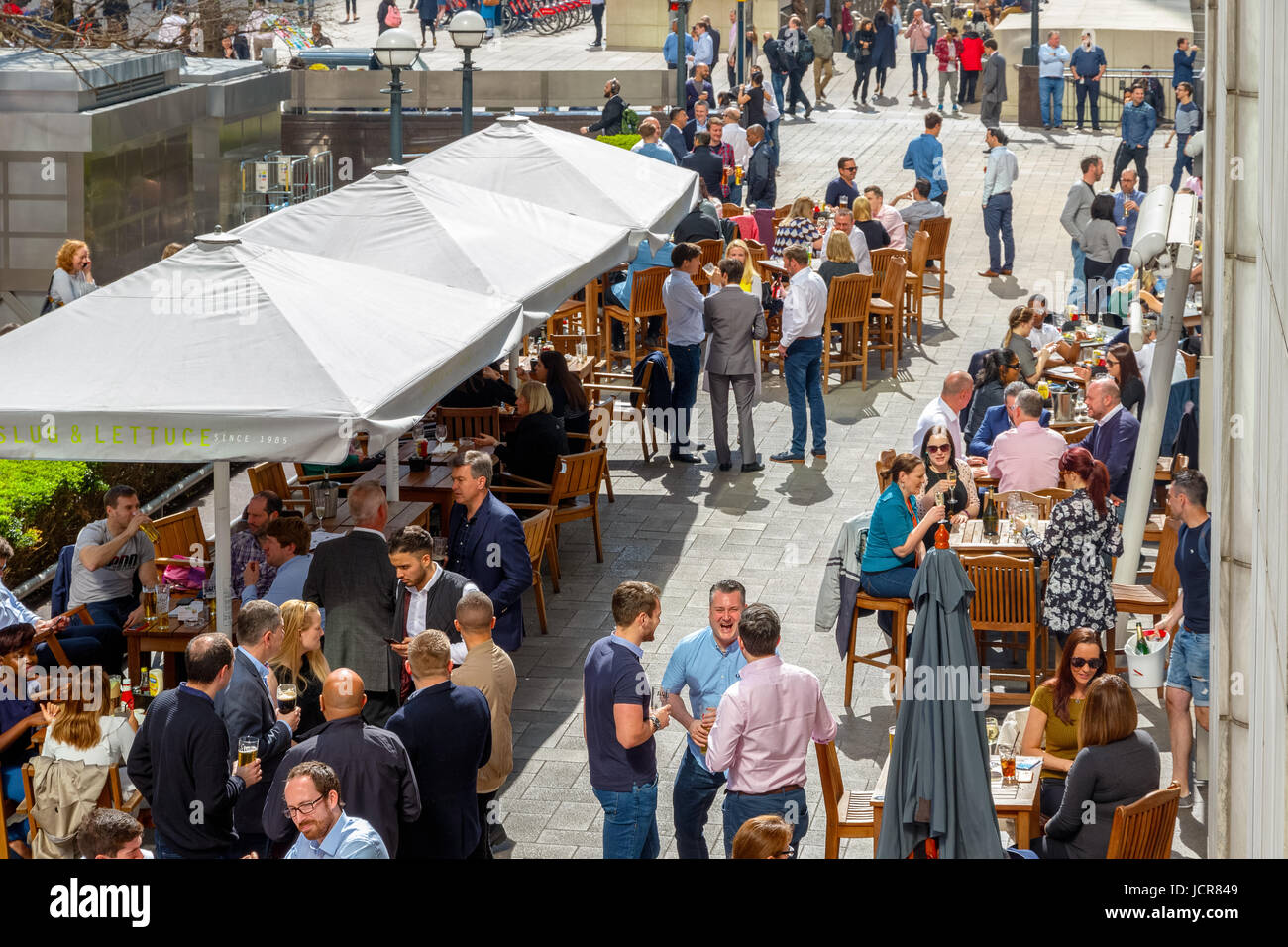 London, UK - May 10, 2017 - An outdoor bar in Canary Wharf packed with ...