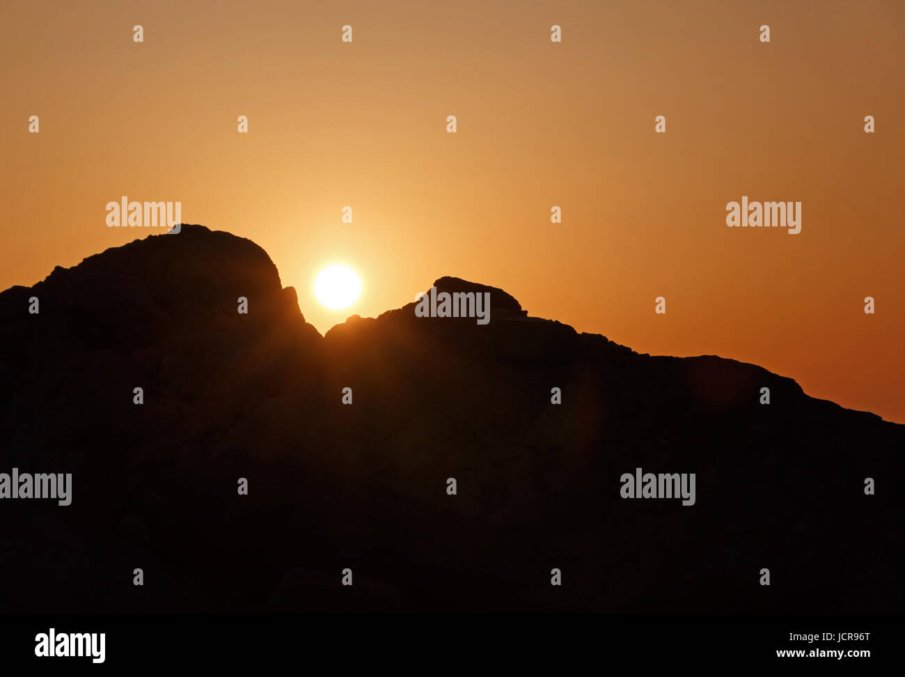 landscape with sun rising between two rocks Stock Photo - Alamy