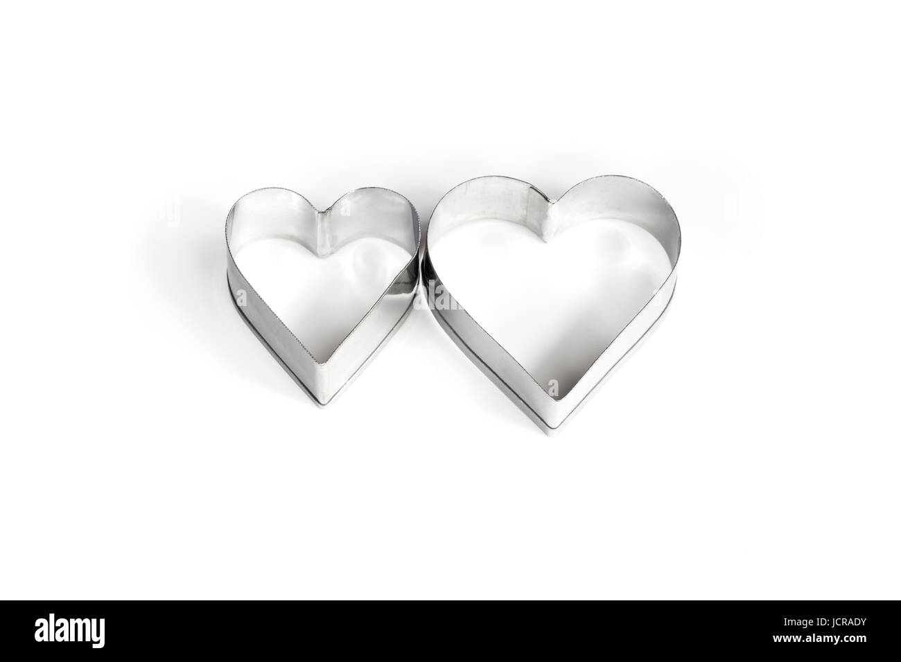 Two metal hearts on white background Stock Photo - Alamy