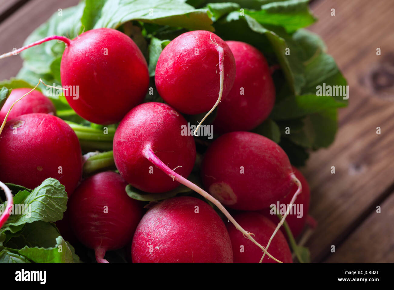 A bunch of radishes on a wooden table Stock Photo - Alamy