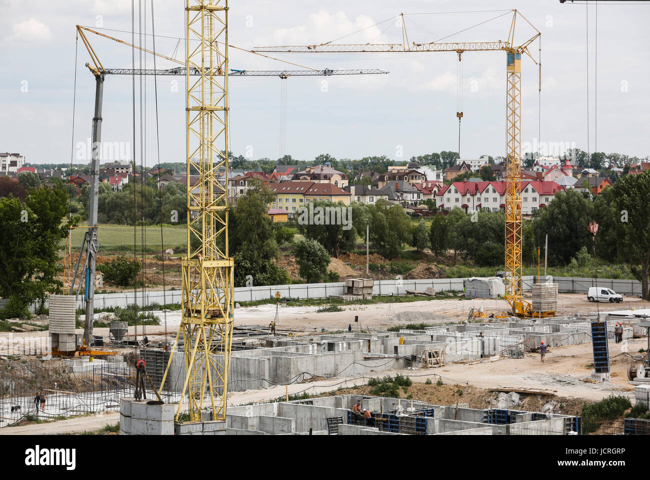 Cranes and construction workers are seen at construction site in Kyiv ...