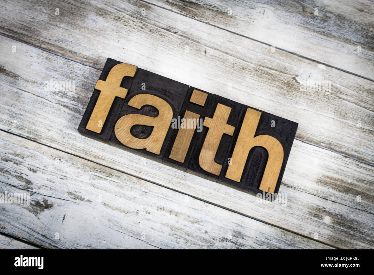 The word "faith" written in wooden letterpress type on a white washed ...