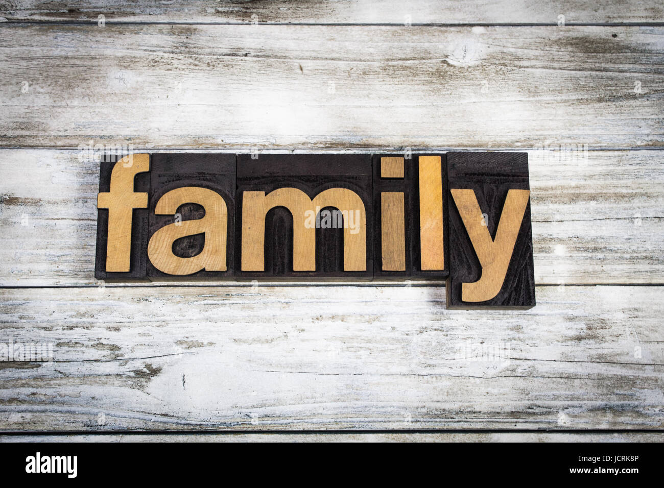 The word "family" written in wooden letterpress type on a white washed ...