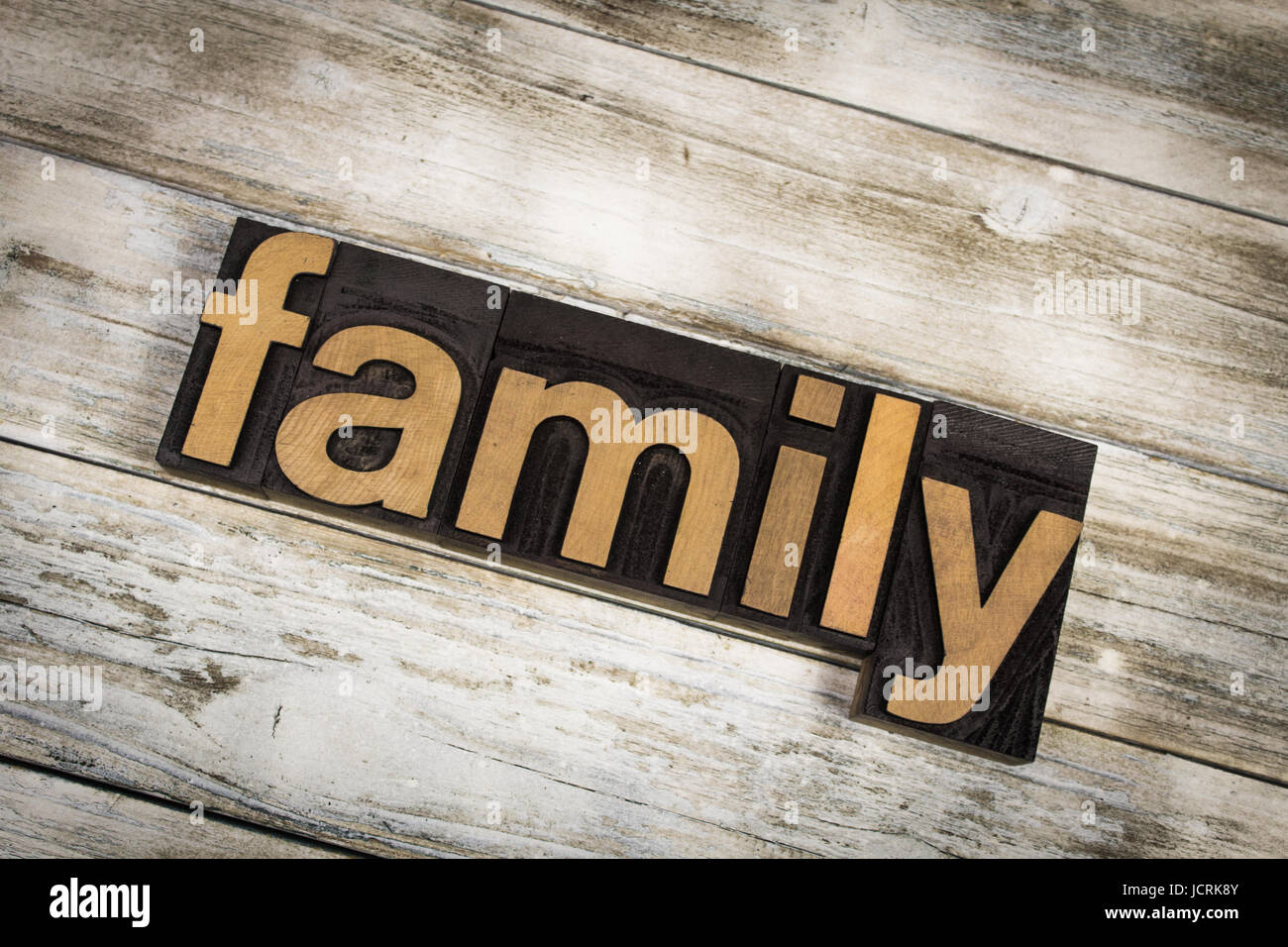 The word "family" written in wooden letterpress type on a white washed ...