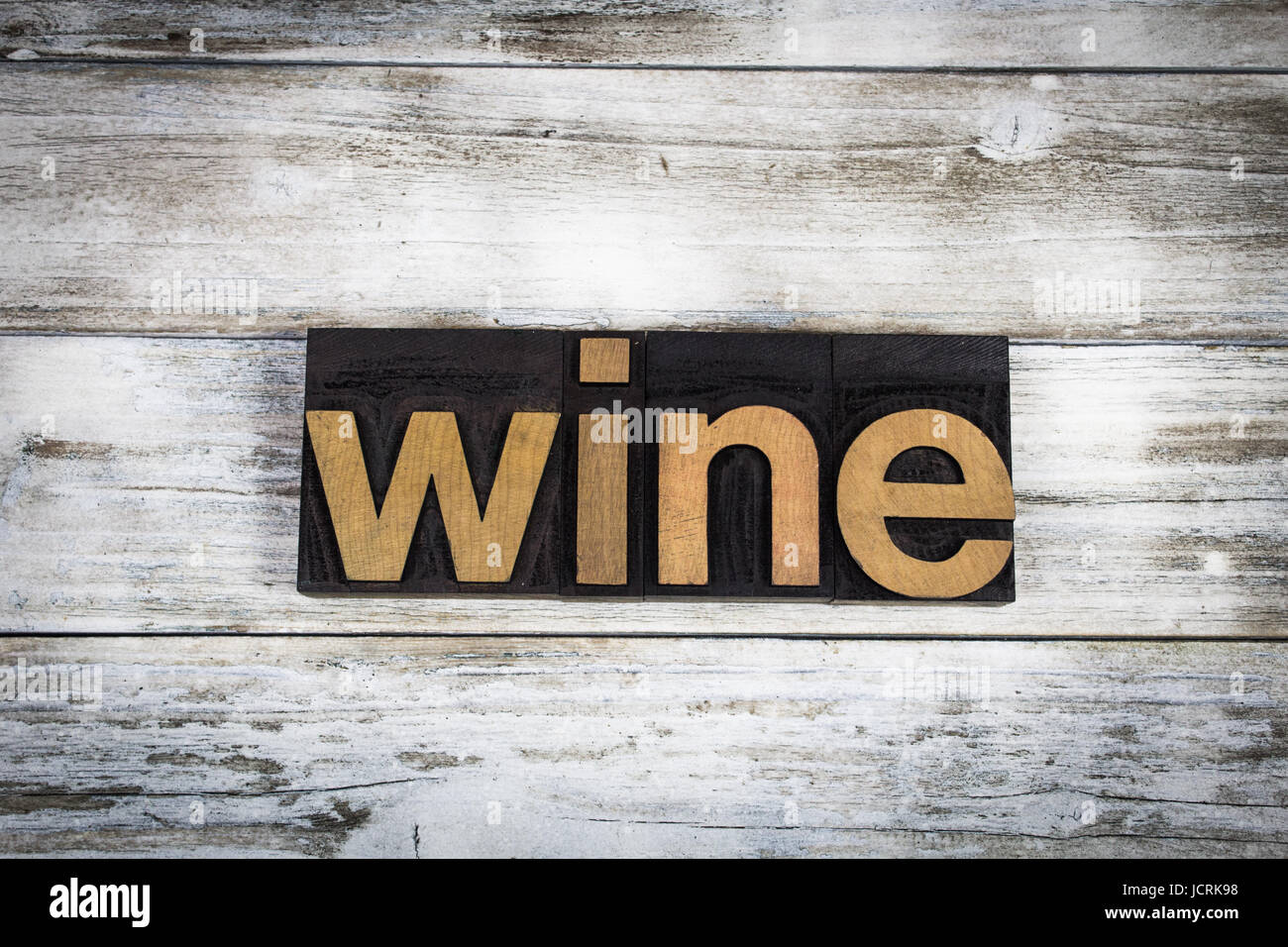 The word "wine" written in wooden letterpress type on a white washed ...