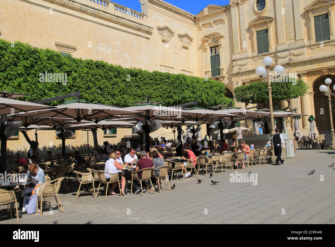 People at cafe tables next to National Library building, Republic ...