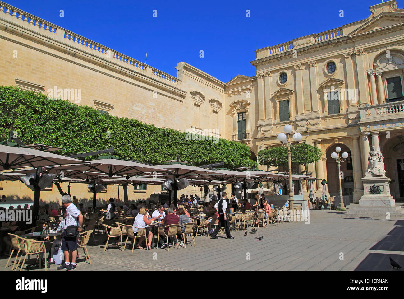 People at cafe tables next to National Library building, Republic ...