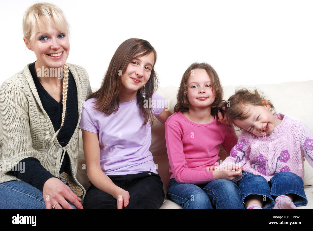 Family sitting in living room on sofa Stock Photo - Alamy