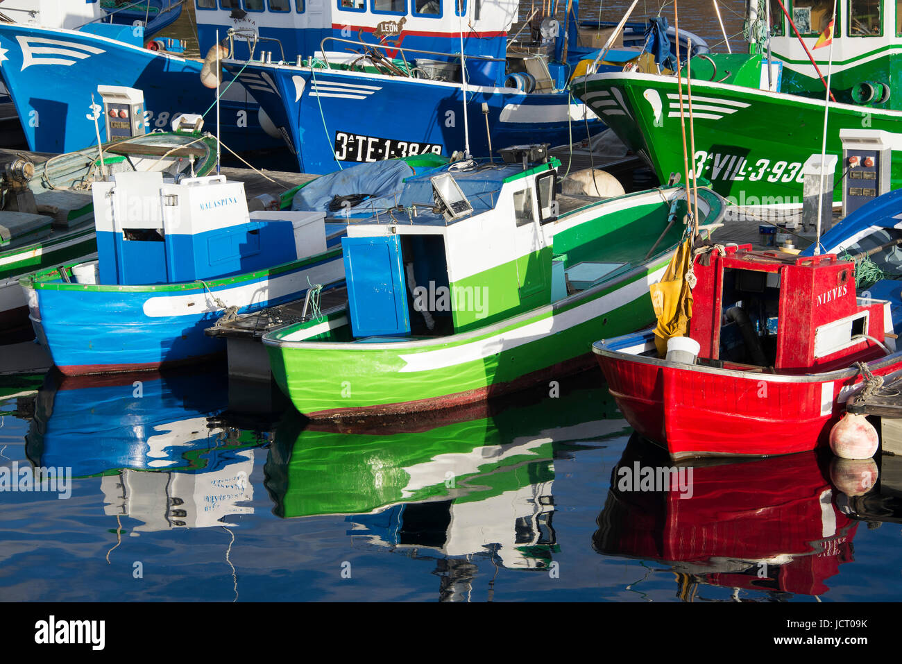 Brightly coloured fishing boats moored at the harbour in Puerto Del ...