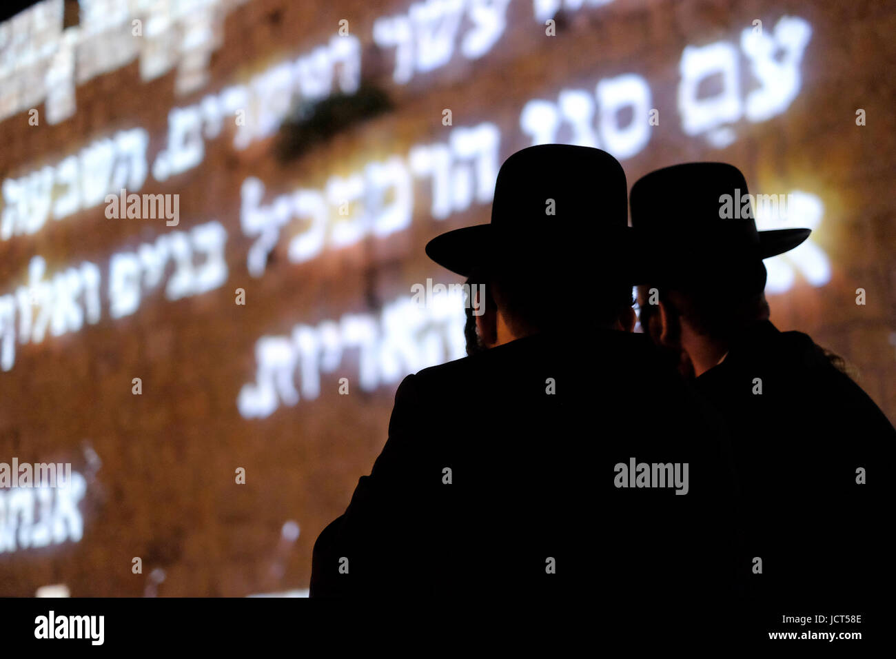 Orthodox Jews looking at a light show projection on the walls of the ...