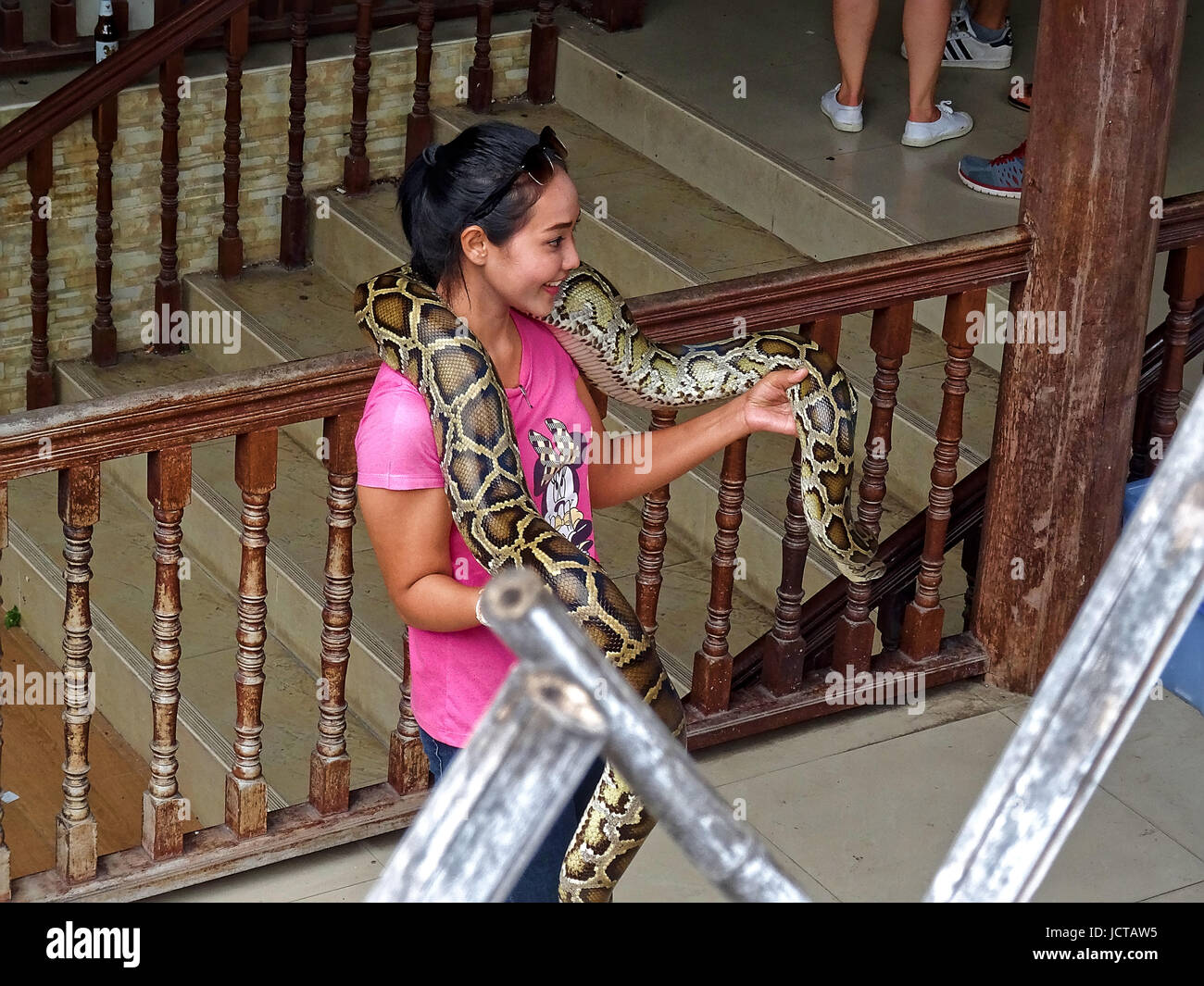 Young girl poses with a Python snake in next to Bangkok Damnoen Saduak ...