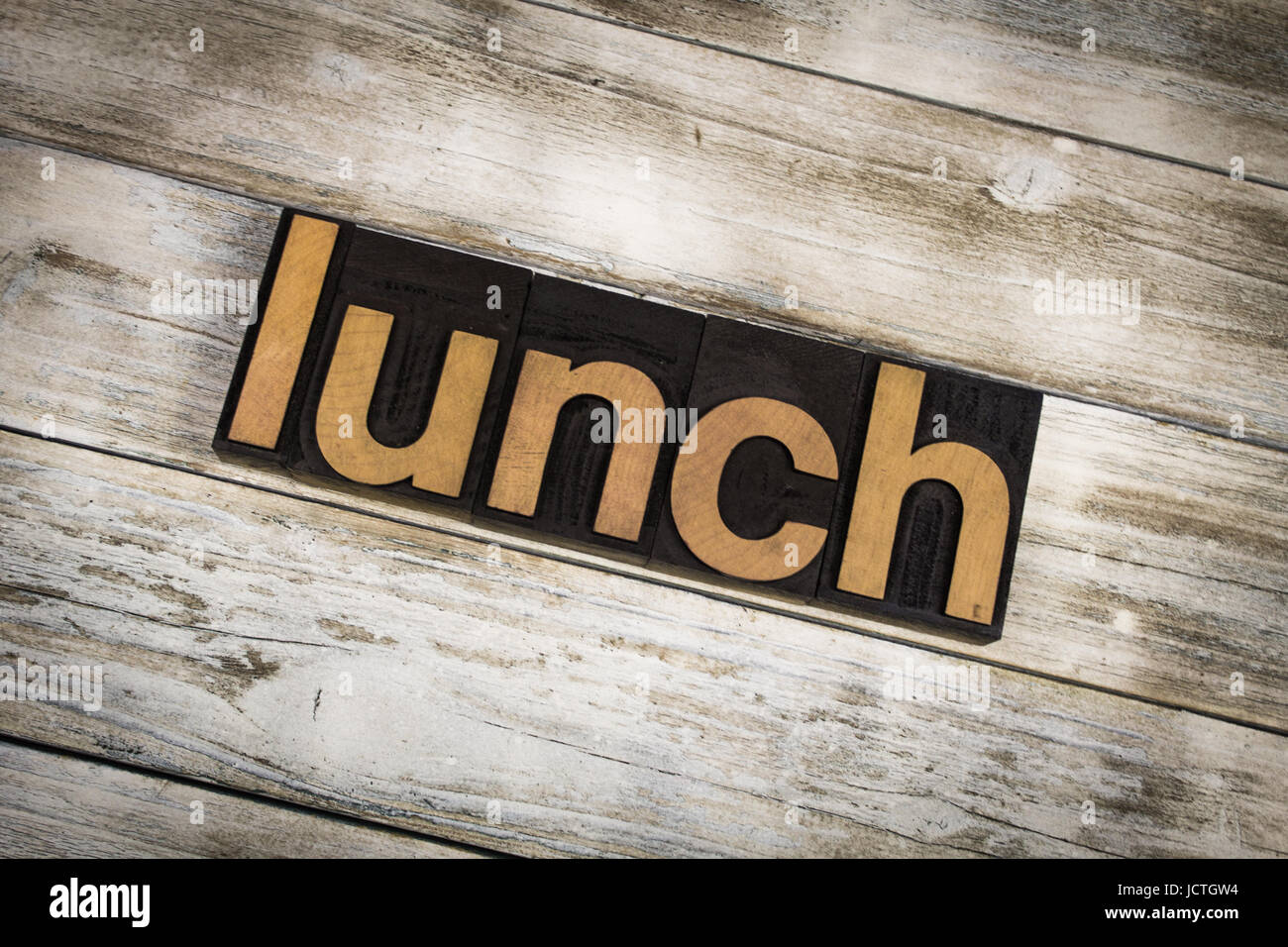 The word "lunch" written in wooden letterpress type on a white washed ...