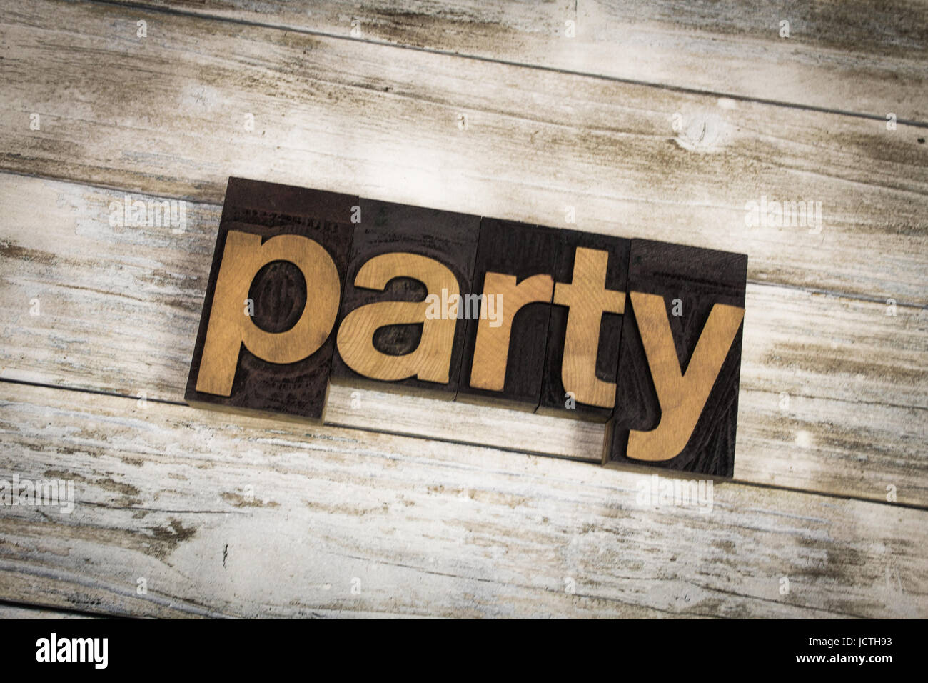 The word "party" written in wooden letterpress type on a white washed ...