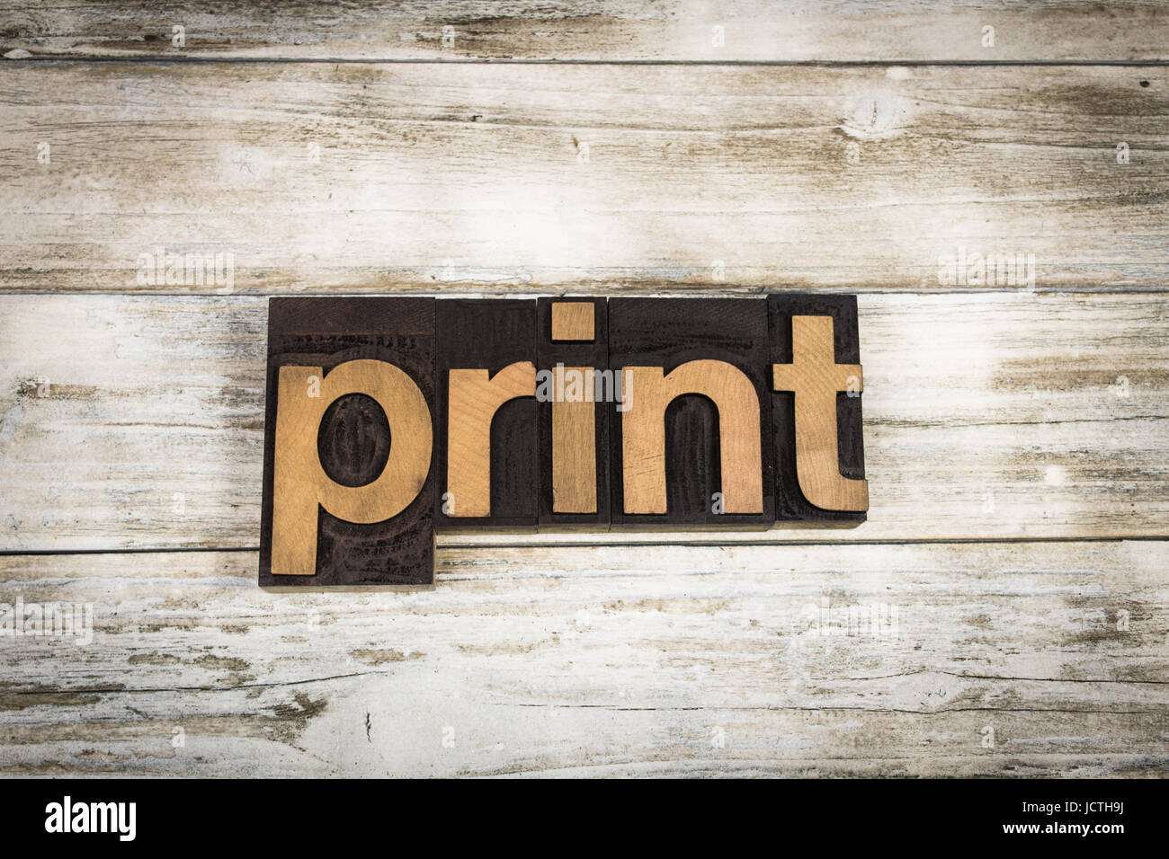 The word "print" written in wooden letterpress type on a white washed ...
