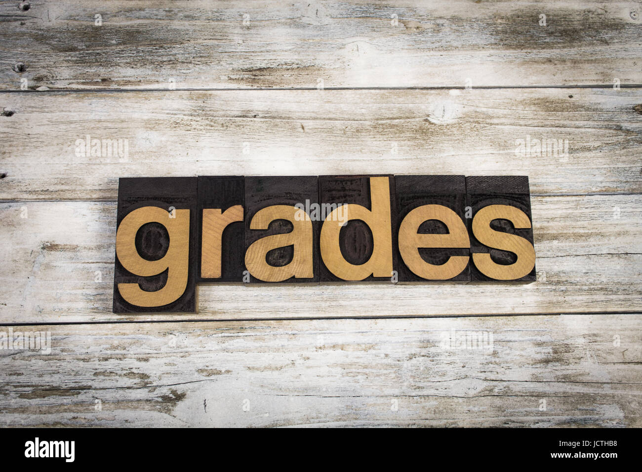 The word "grades" written in wooden letterpress type on a white washed ...