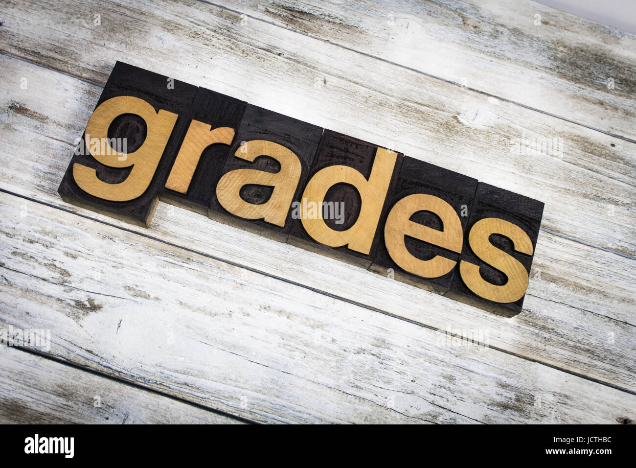 The word "grades" written in wooden letterpress type on a white washed ...