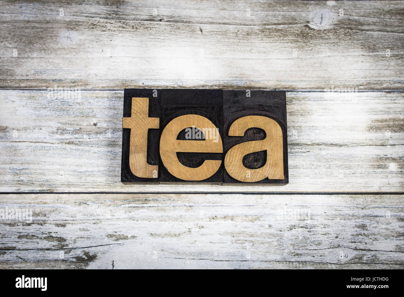 The word "tea" written in wooden letterpress type on a white washed old ...