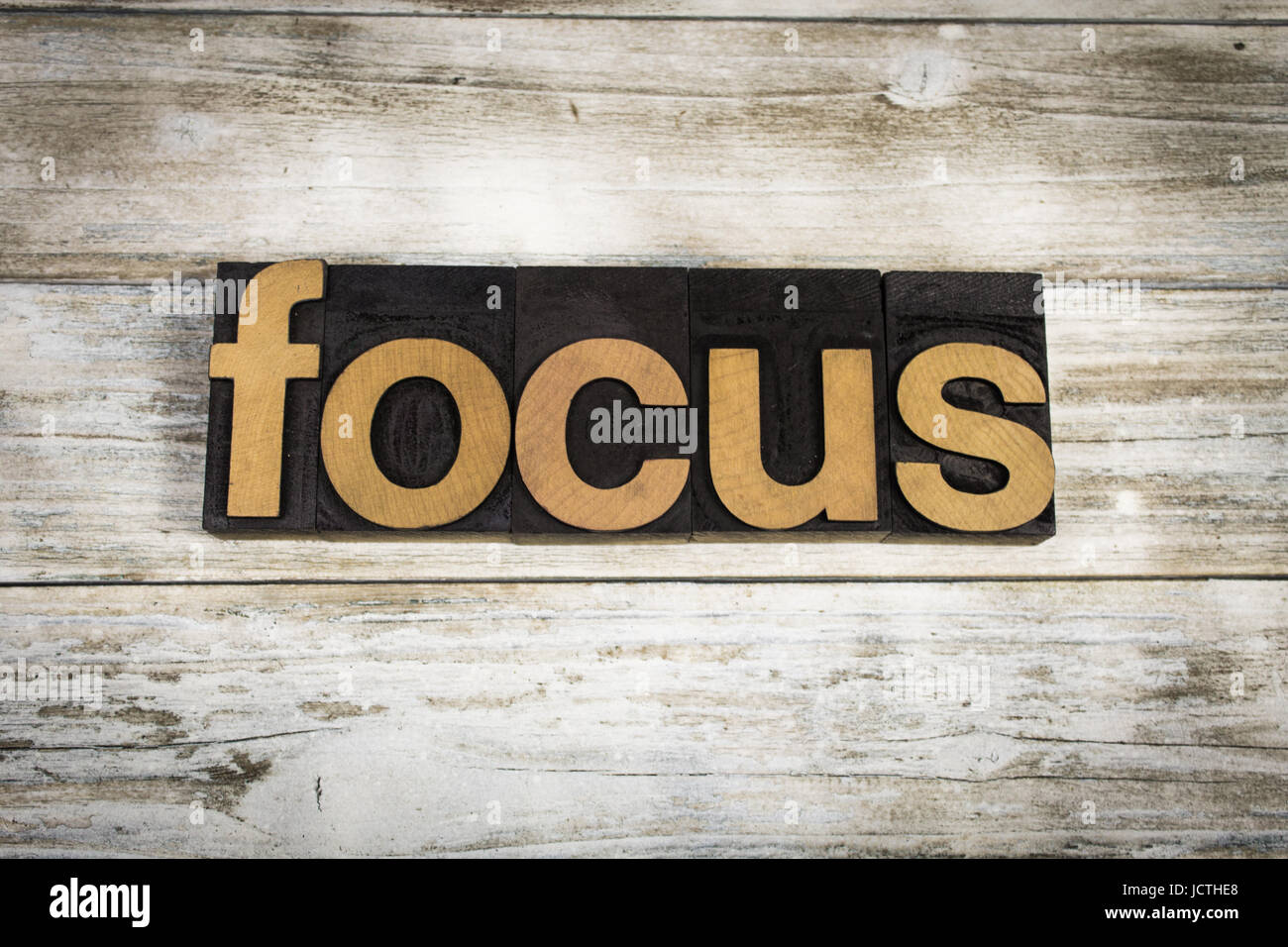 The word "focus" written in wooden letterpress type on a white washed ...