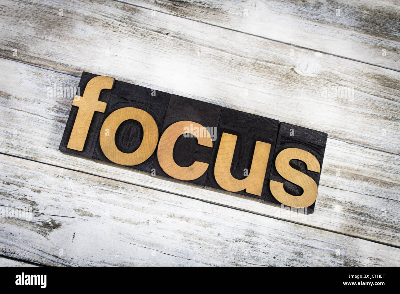 The word "focus" written in wooden letterpress type on a white washed ...