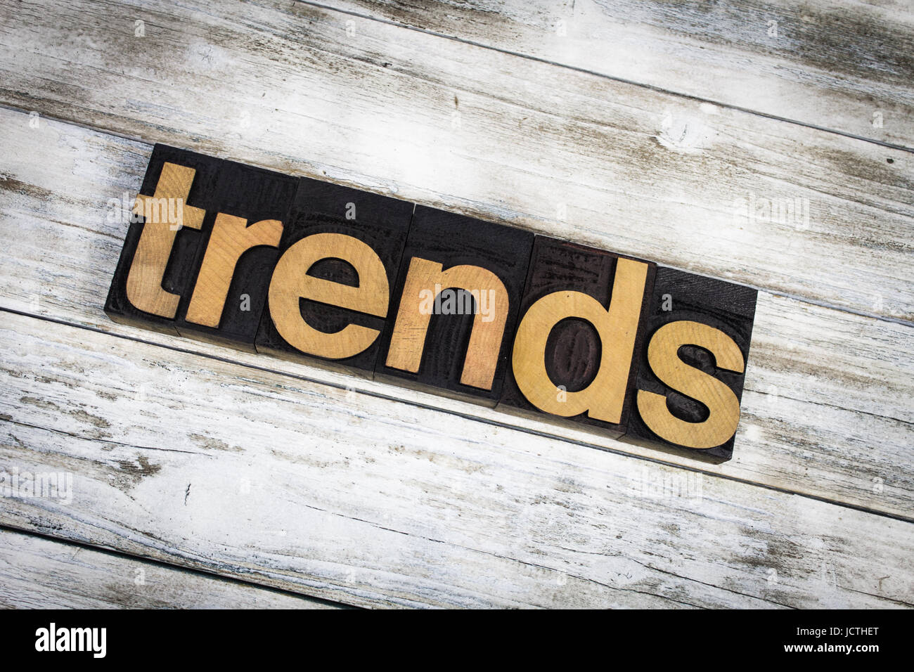 The word "trends" written in wooden letterpress type on a white washed ...