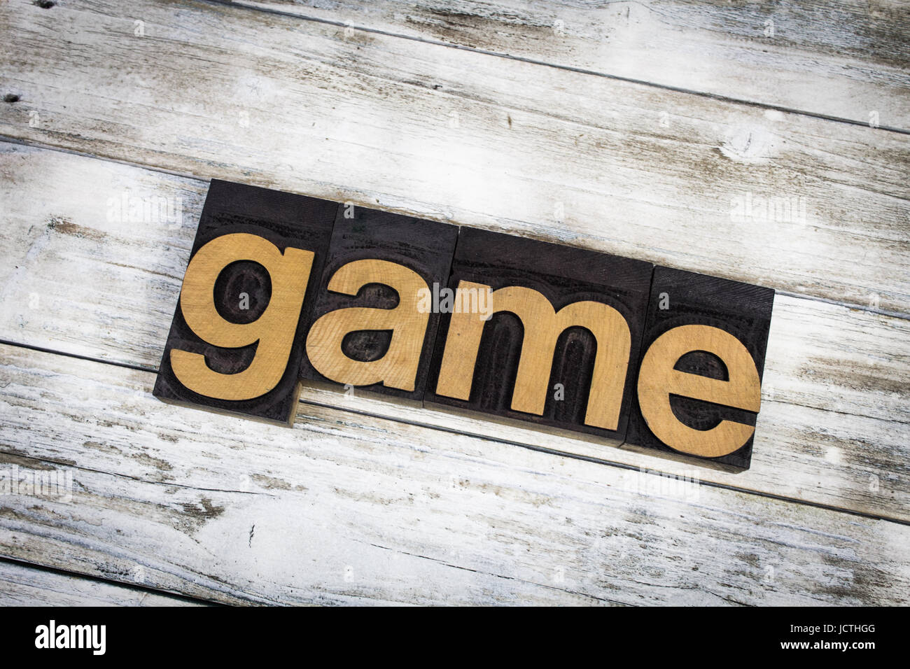 The word "game" written in wooden letterpress type on a white washed ...