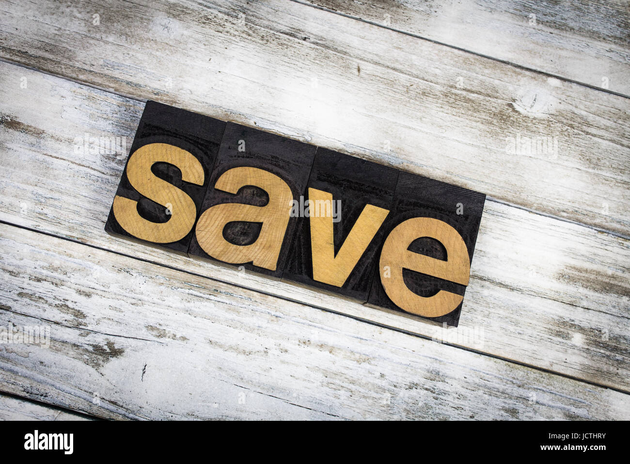 The word "save" written in wooden letterpress type on a white washed ...