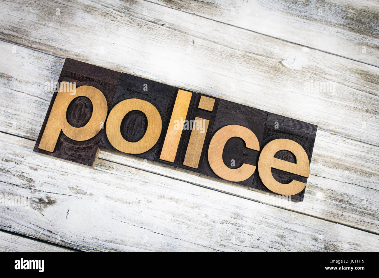 The word "police" written in wooden letterpress type on a white washed ...
