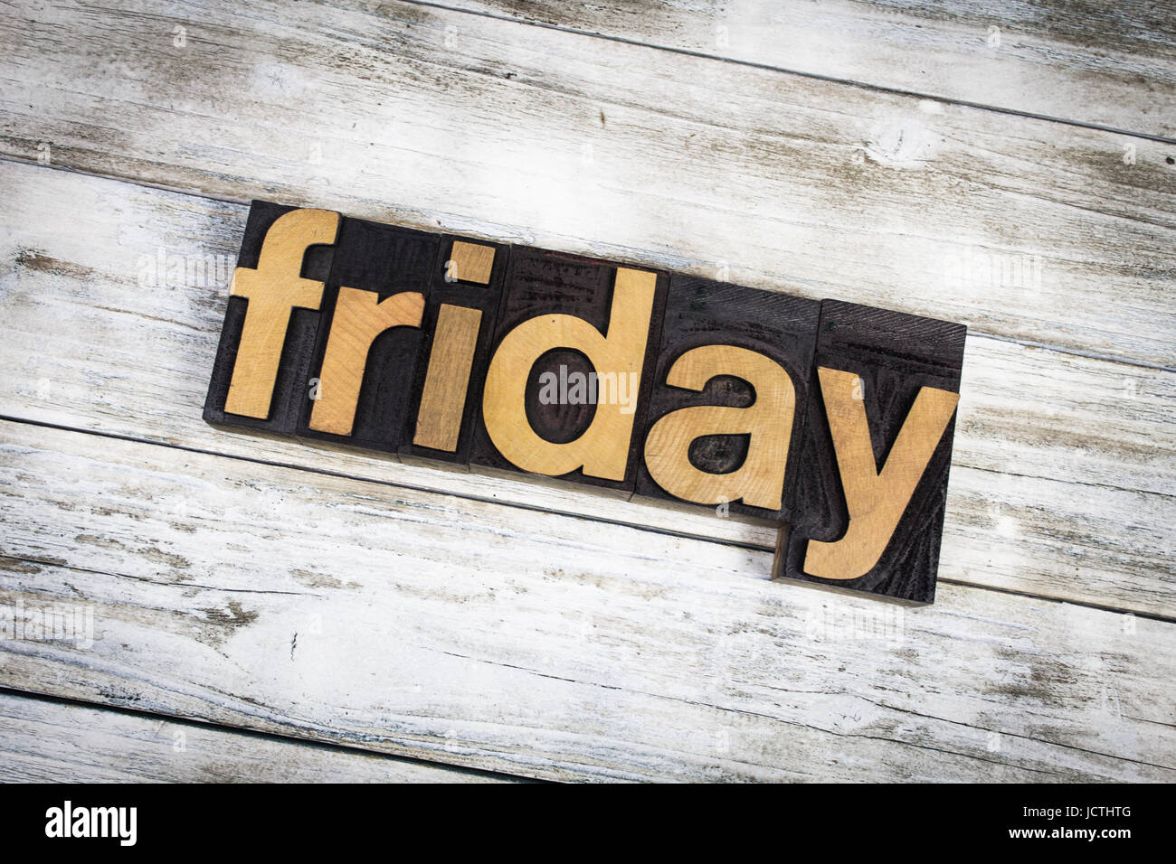 The word "Friday" written in wooden letterpress type on a white washed ...