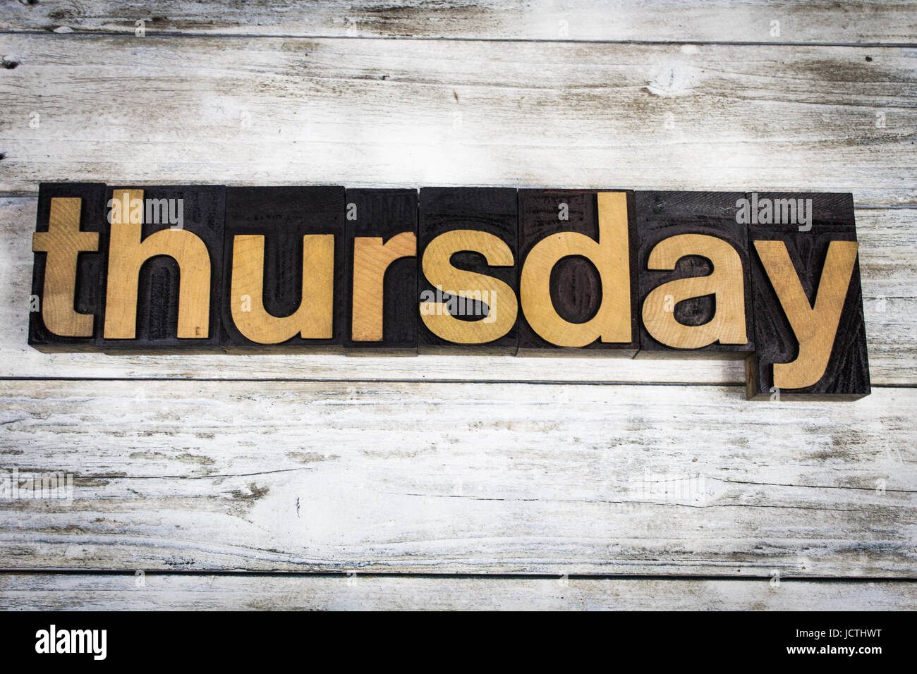 The word "Thursday" written in wooden letterpress type on a white ...