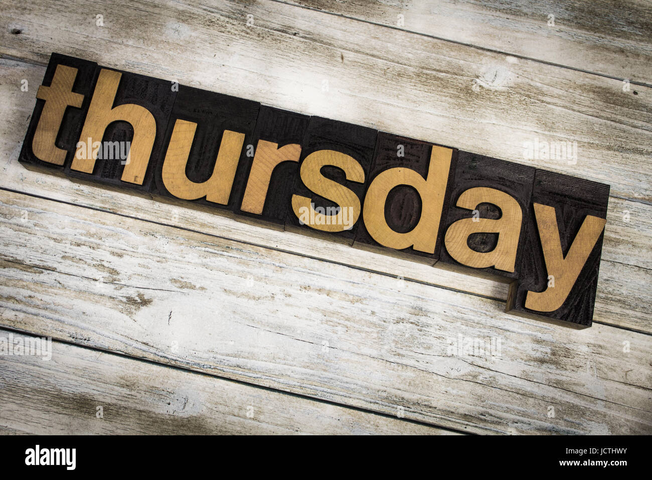 The word "Thursday" written in wooden letterpress type on a white ...