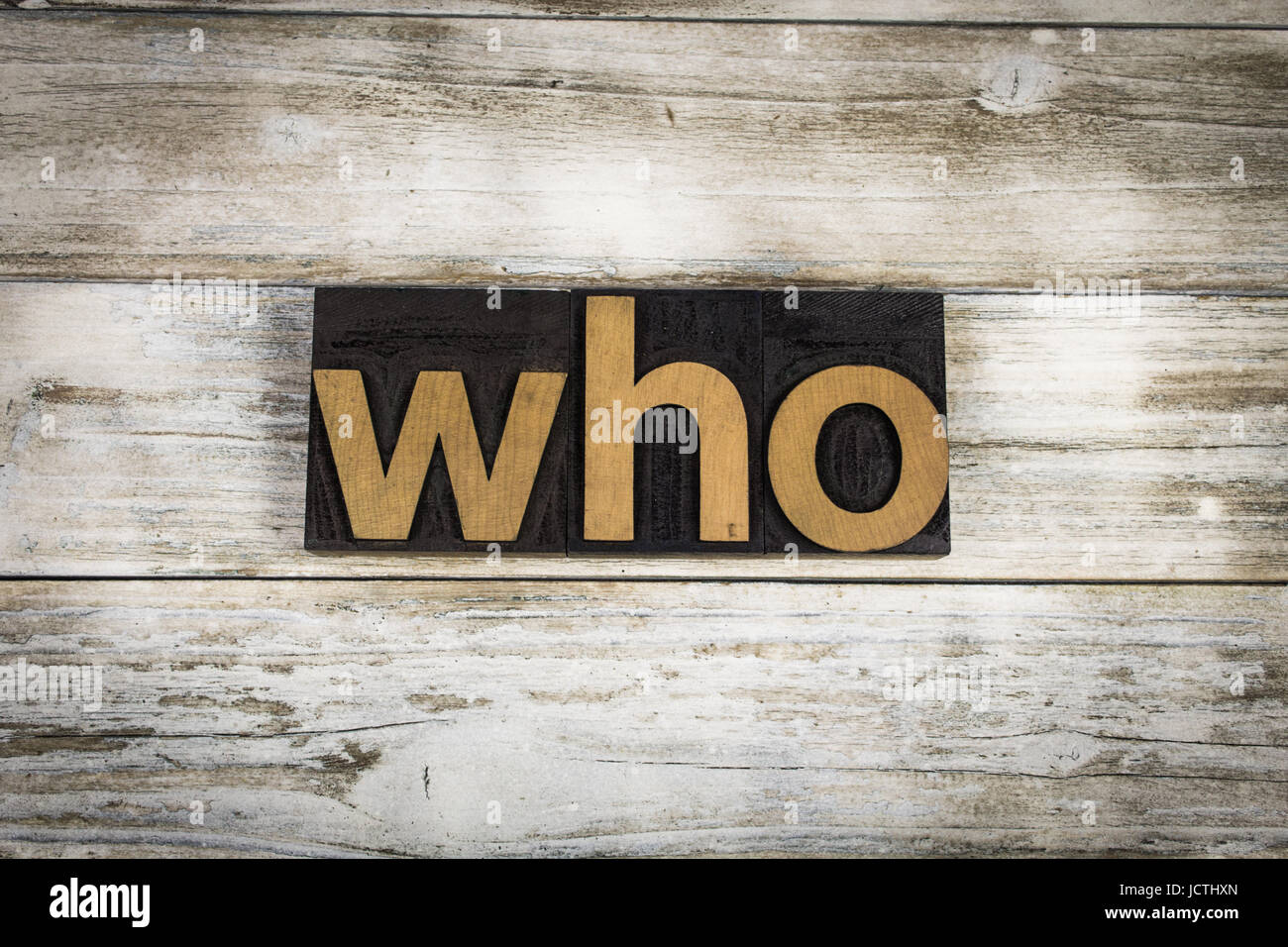 The word "who" written in wooden letterpress type on a white washed old ...