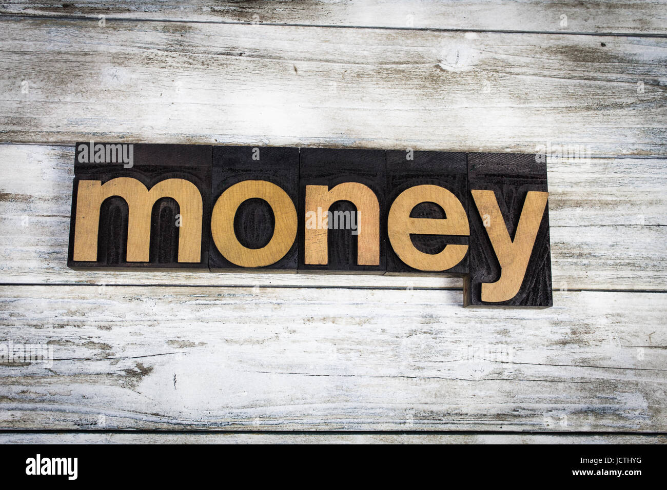 The word "money" written in wooden letterpress type on a white washed ...