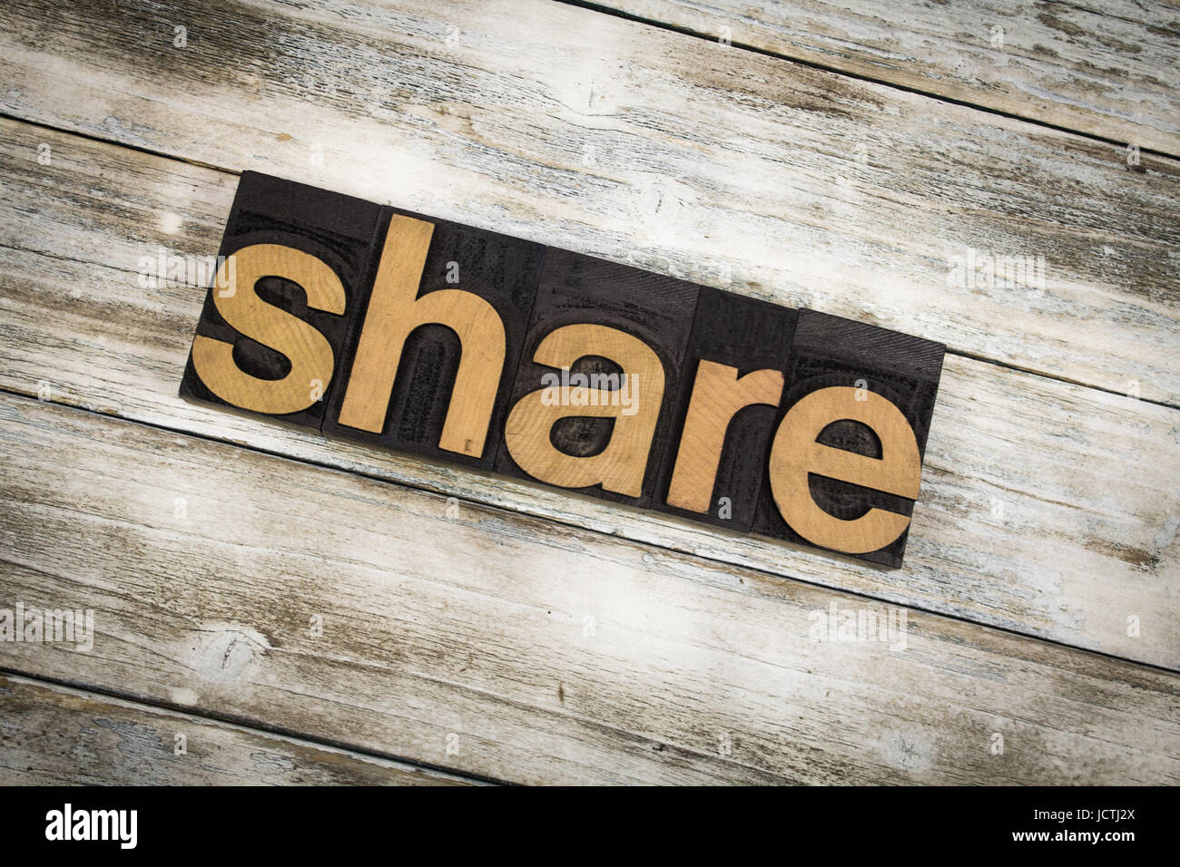 The word "share" written in wooden letterpress type on a white washed ...