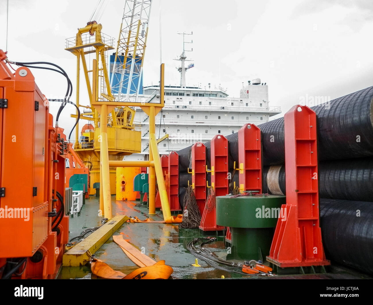 The deck lay barge. Pipes and Lifting cranes on the ship. Equipment for ...