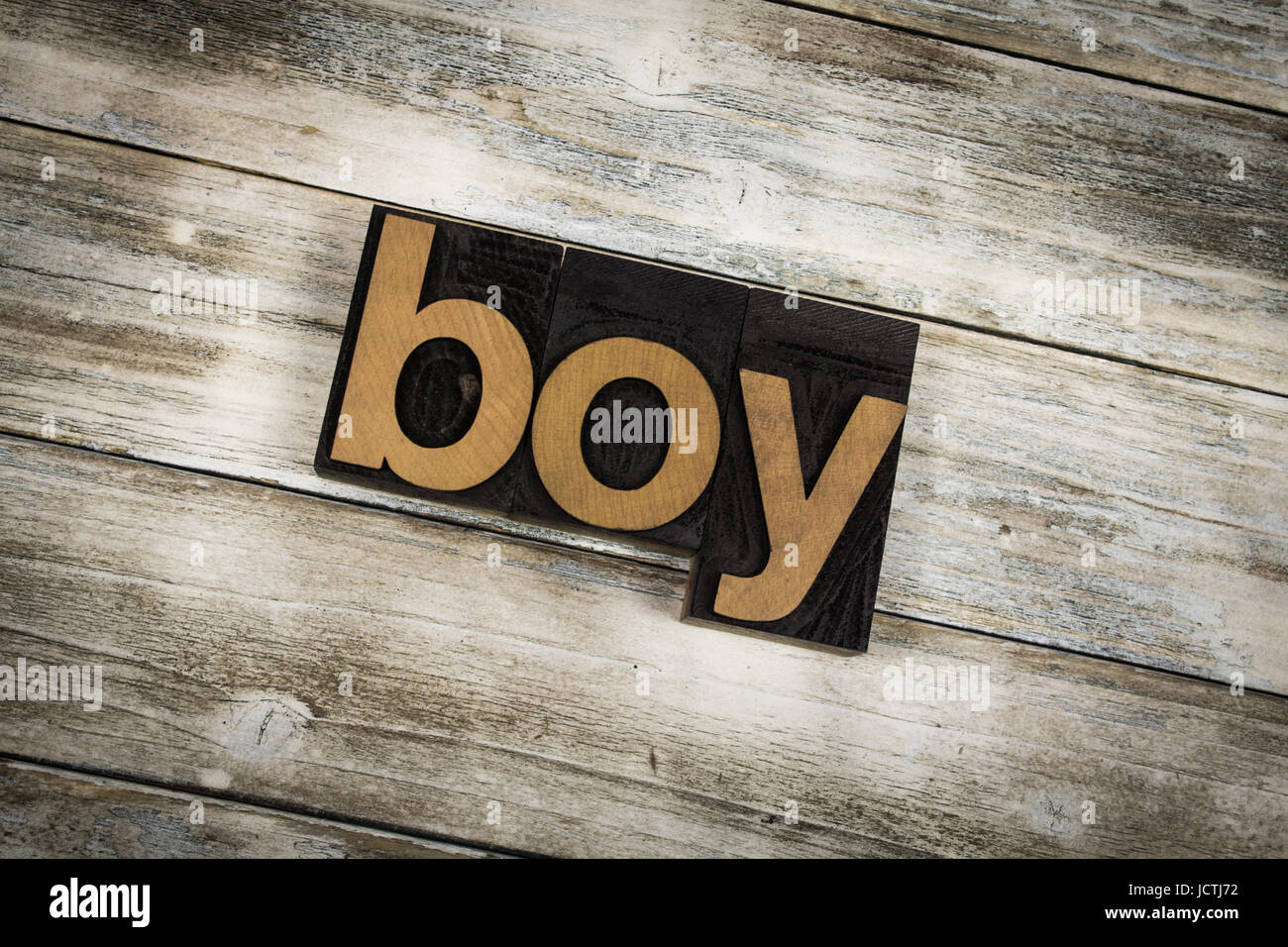 The word "boy" written in wooden letterpress type on a white washed old ...