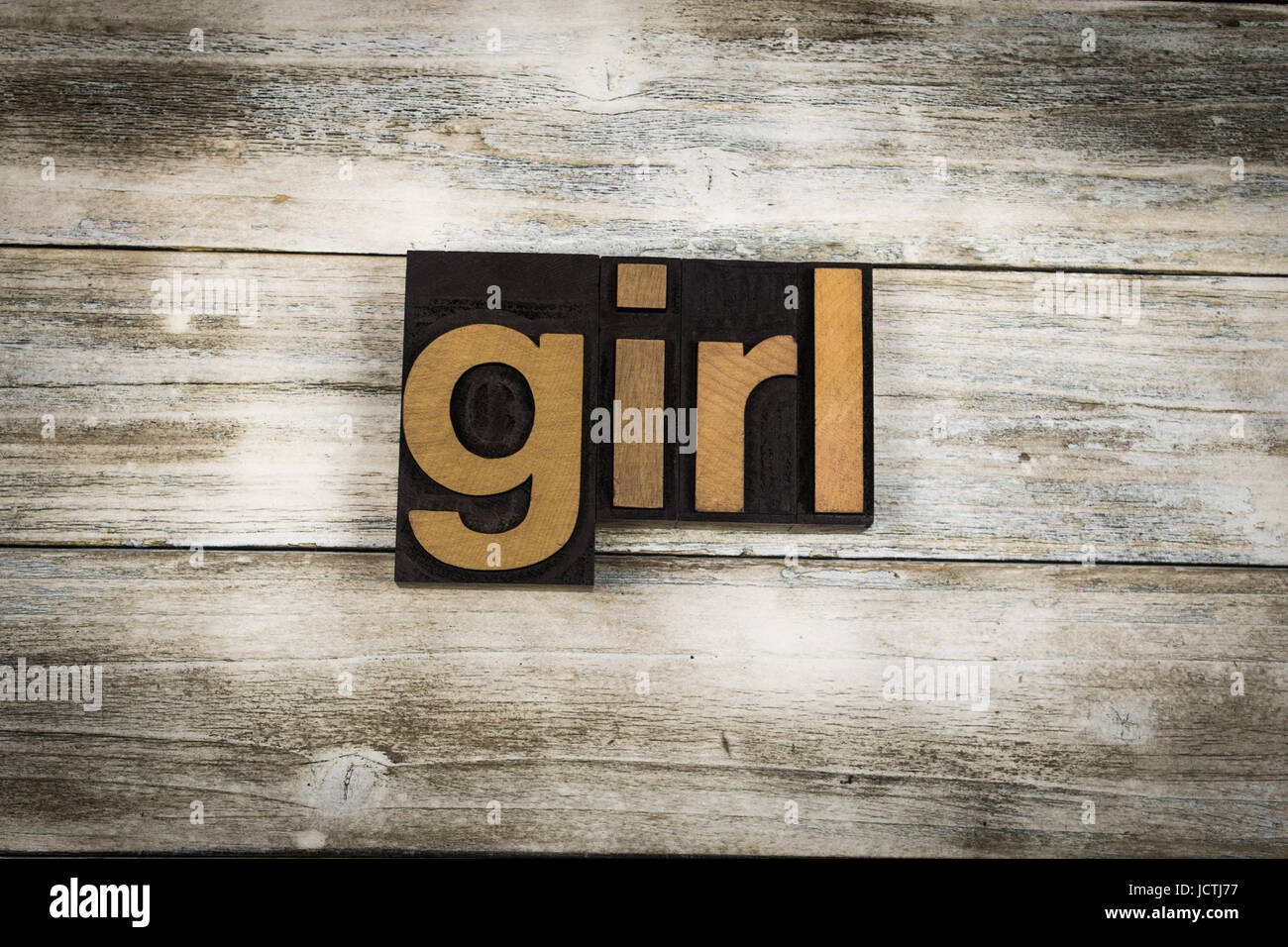 The word "girl" written in wooden letterpress type on a white washed ...