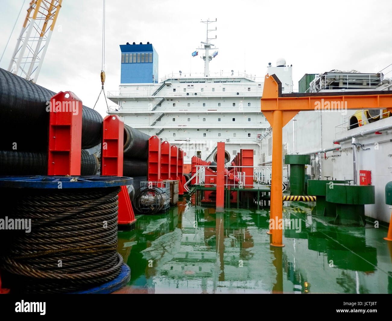 The deck lay barge. Pipes and Lifting cranes on the ship. Equipment for ...