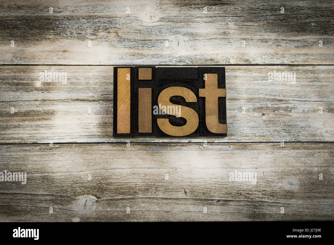 The word "list" written in wooden letterpress type on a white washed ...