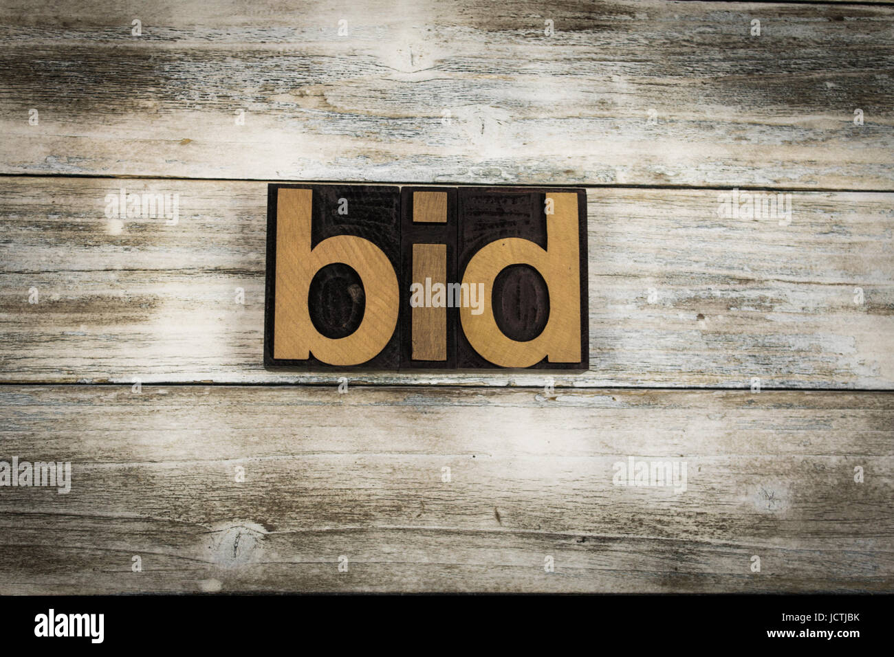 The word "bid" written in wooden letterpress type on a white washed old ...