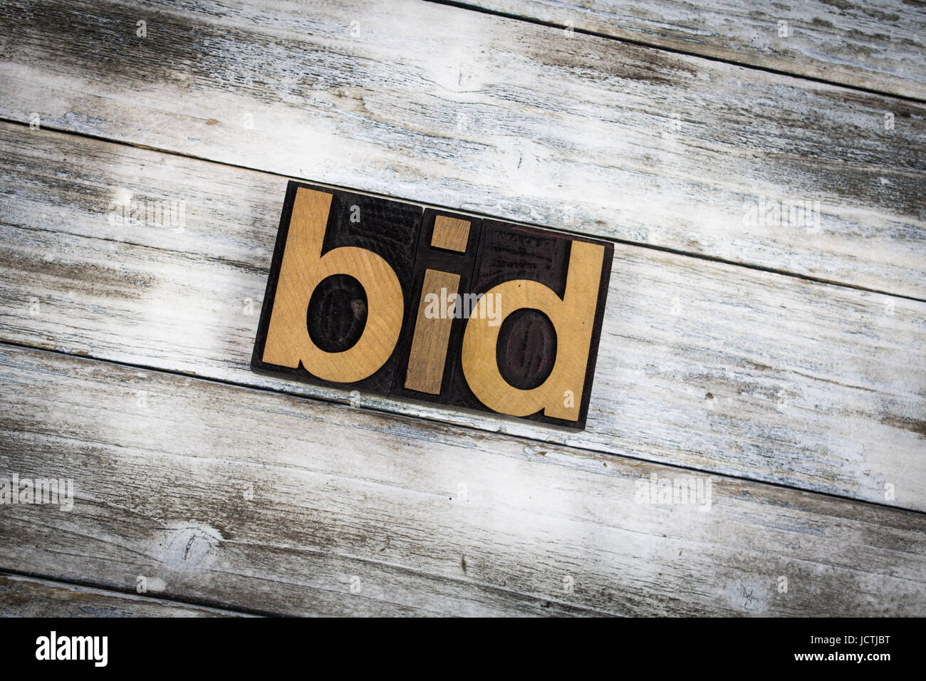 The word "bid" written in wooden letterpress type on a white washed old ...