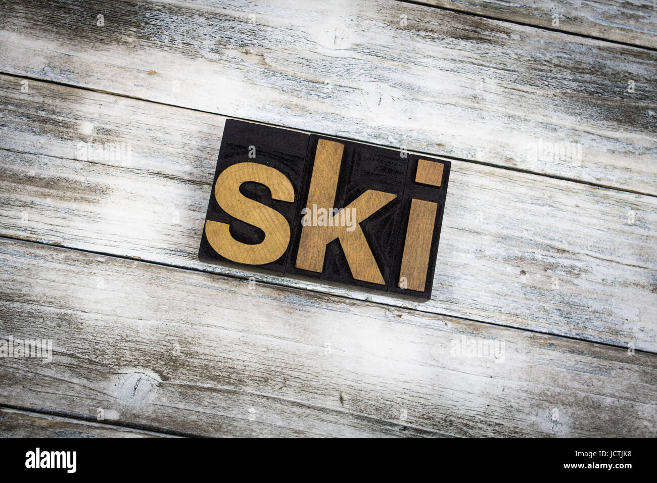 The word "ski" written in wooden letterpress type on a white washed old ...