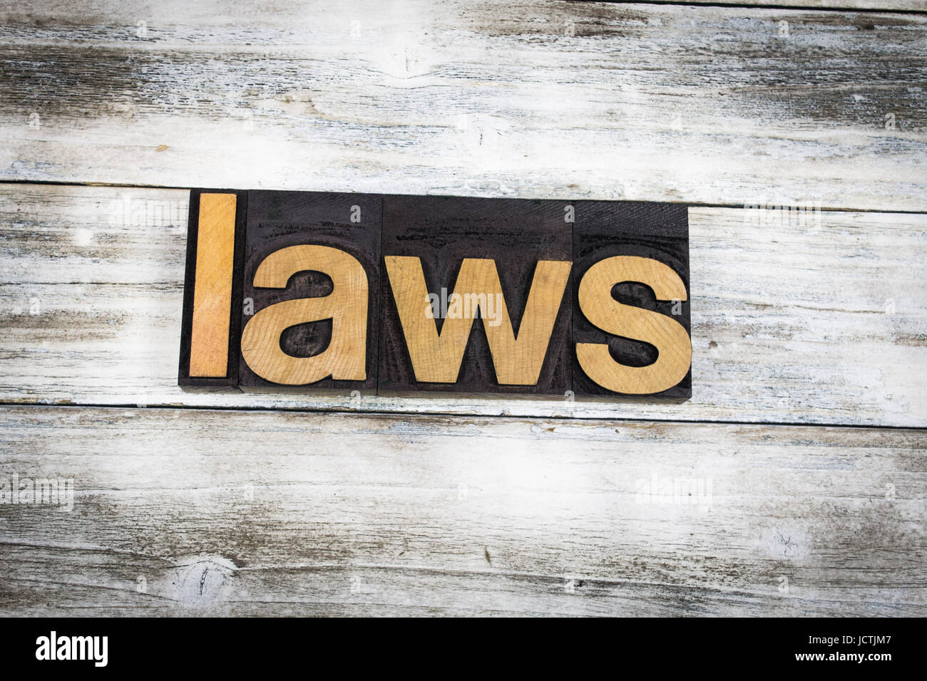 The word "laws" written in wooden letterpress type on a white washed ...