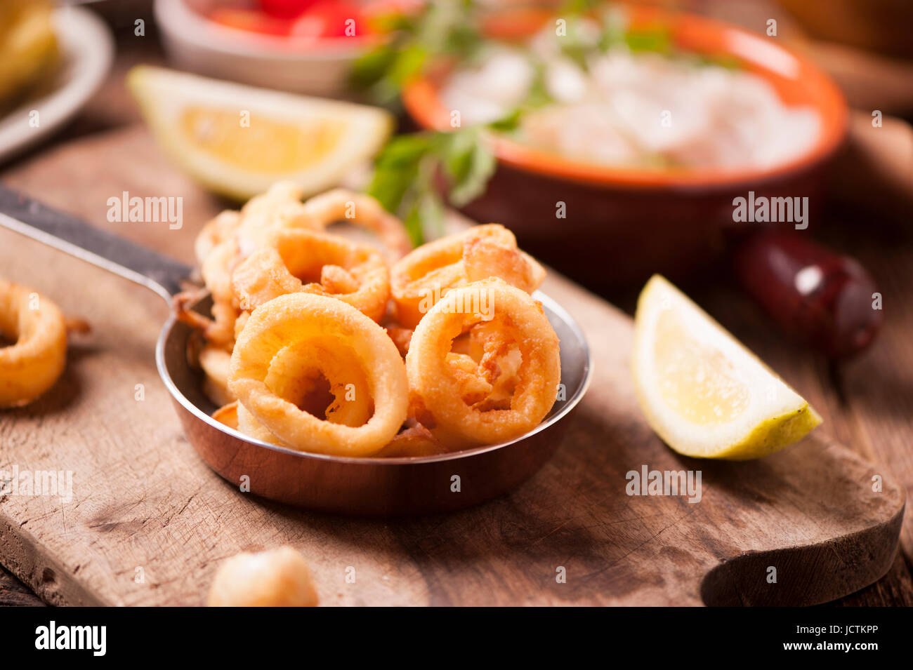 crispy calamari rings on wooden table Stock Photo - Alamy