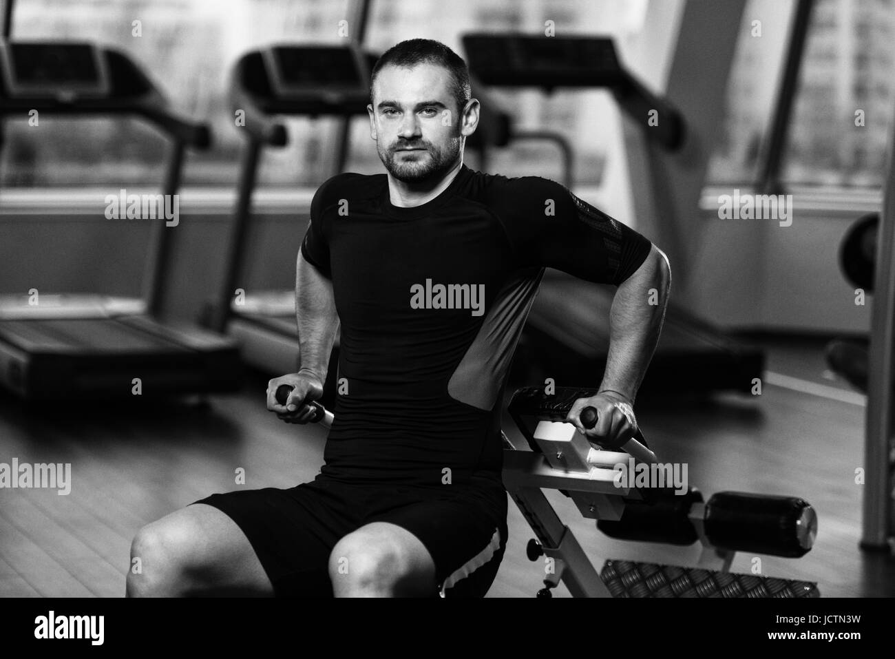 Young Fitness Man Working Out Triceps On Roman Chair In Fitness Center ...
