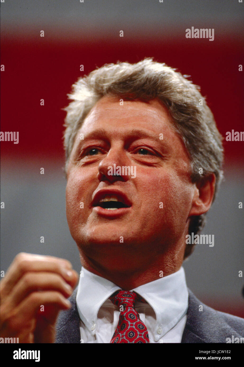 President Bill Clinton while speaking. A large American flag hangs ...
