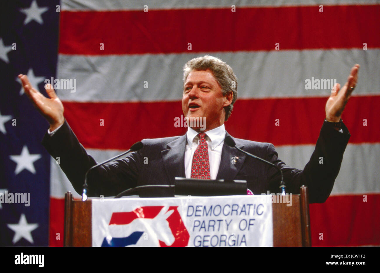 President Bill Clinton speaks in front of a large American flag Stock ...