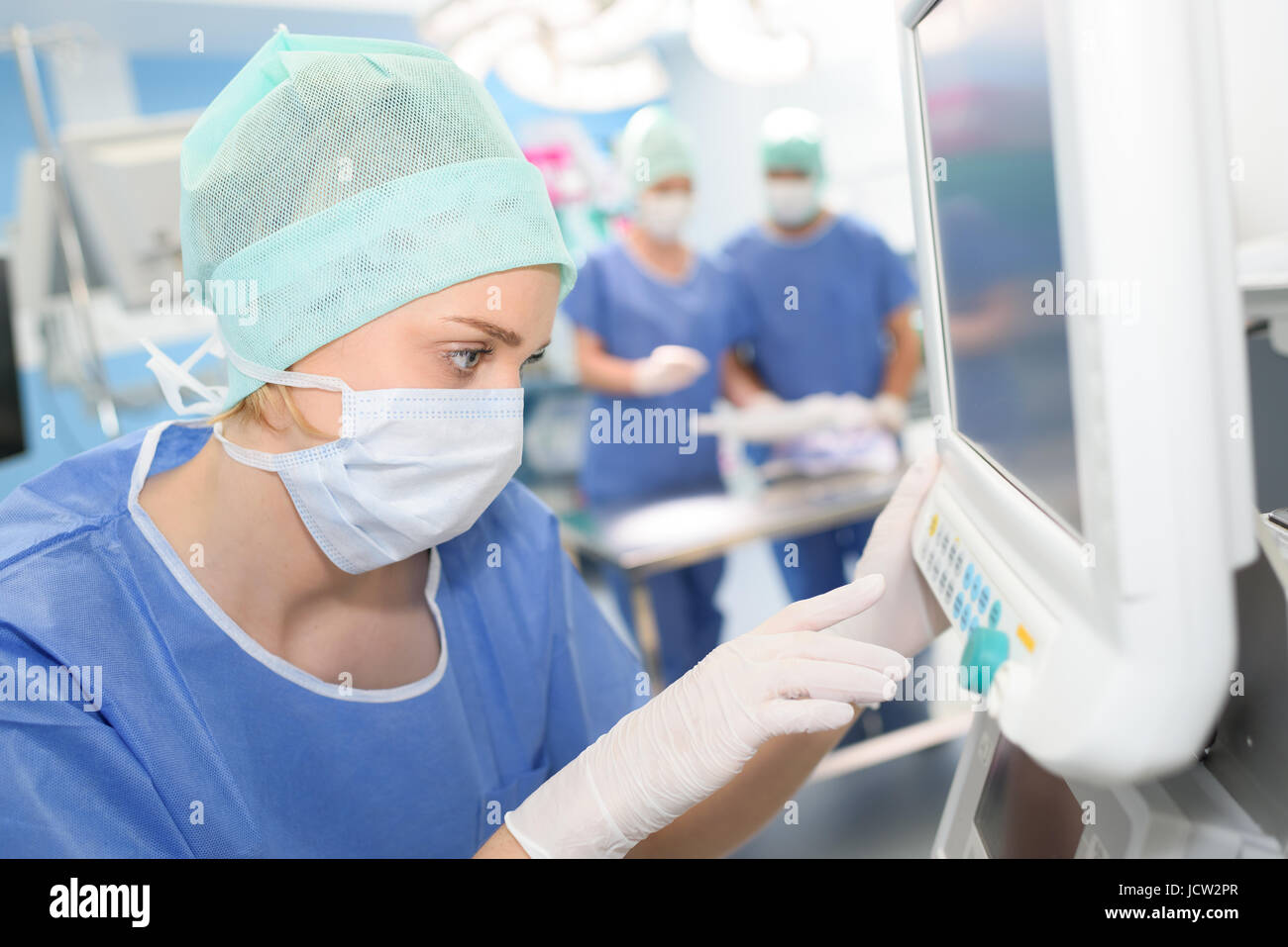 surgeon checking ultrasound monitoring of the heart during surgery ...
