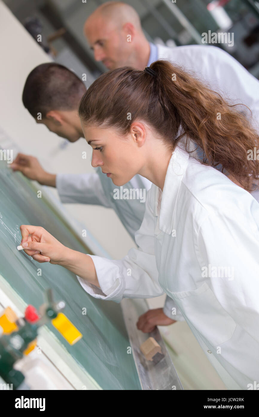 Students writing on board with chalk Stock Photo - Alamy